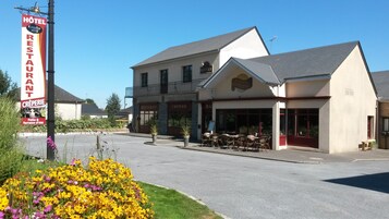 Hotel com restaurante e creperia, com varanda e área externa para refeições.