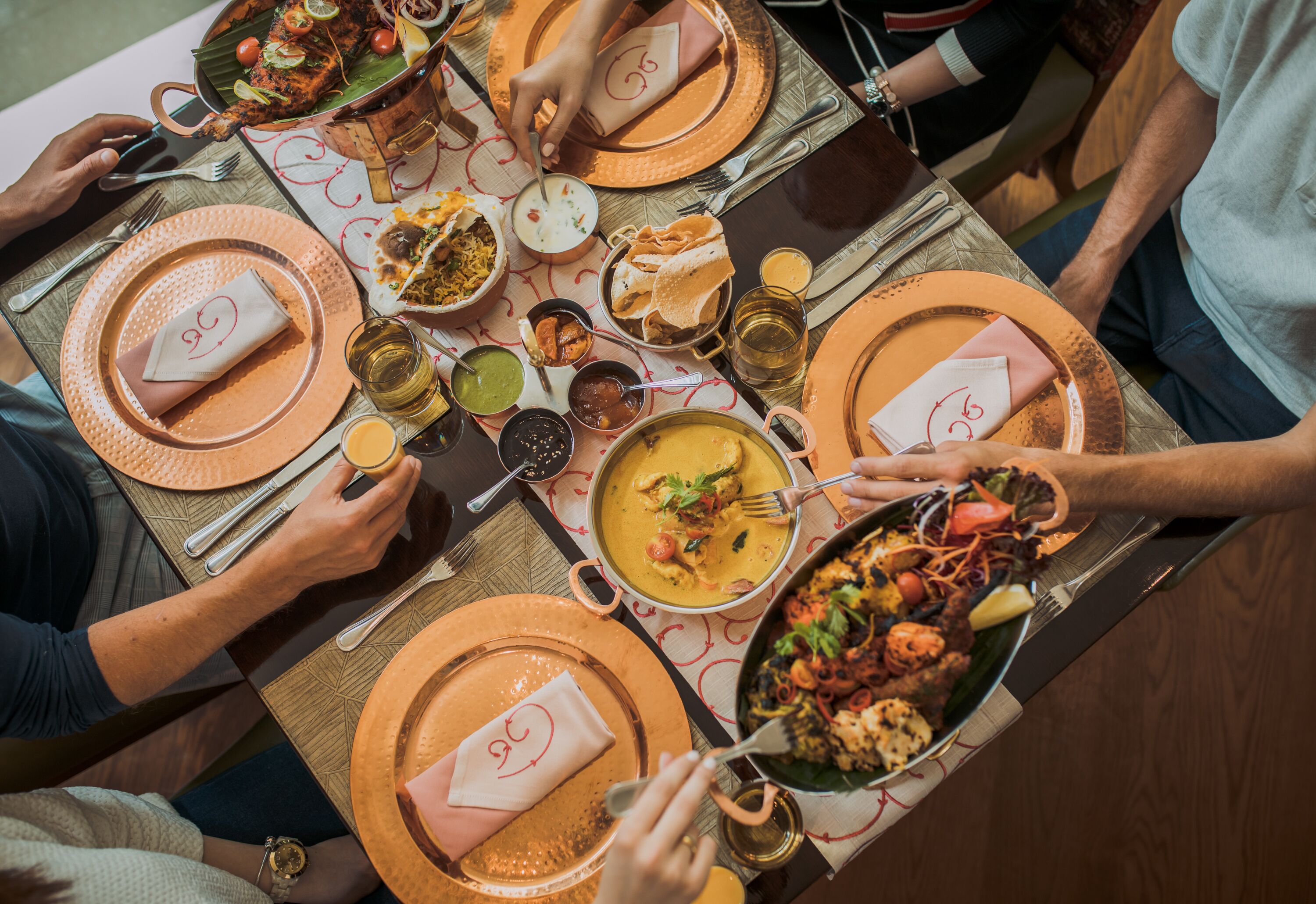 Uma mesa de jantar posta com vários pratos, talheres e copos.