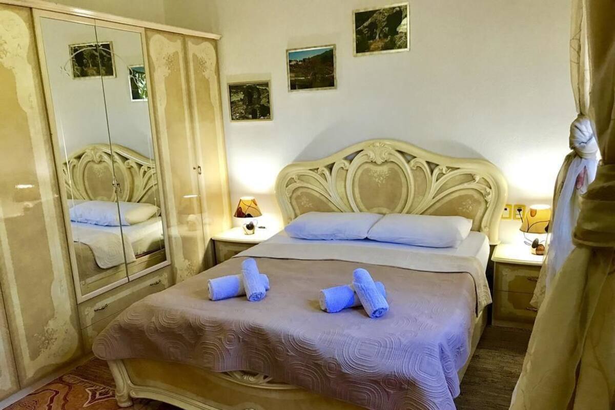 Um quarto com uma cama, um guarda-roupa e uma mesa de cabeceira.