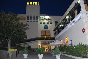 Entrada de hotel com placa indicando a área de recepção.