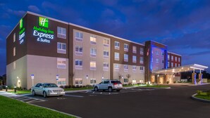 Um hotel Holiday Inn Express & Suites com design moderno, vários andares e estacionamento.