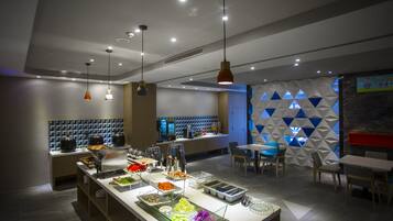 Um café moderno com buffet, área de estar e design geométrico na parede.