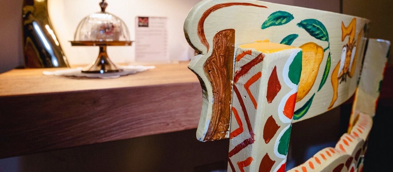 Um balcão de atendimento em madeira com uma vitrine abobadada de vidro.