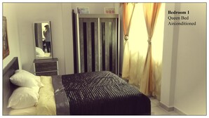 Quarto com cama de casal, ar-condicionado, espelho, guarda-roupa e cortinas.