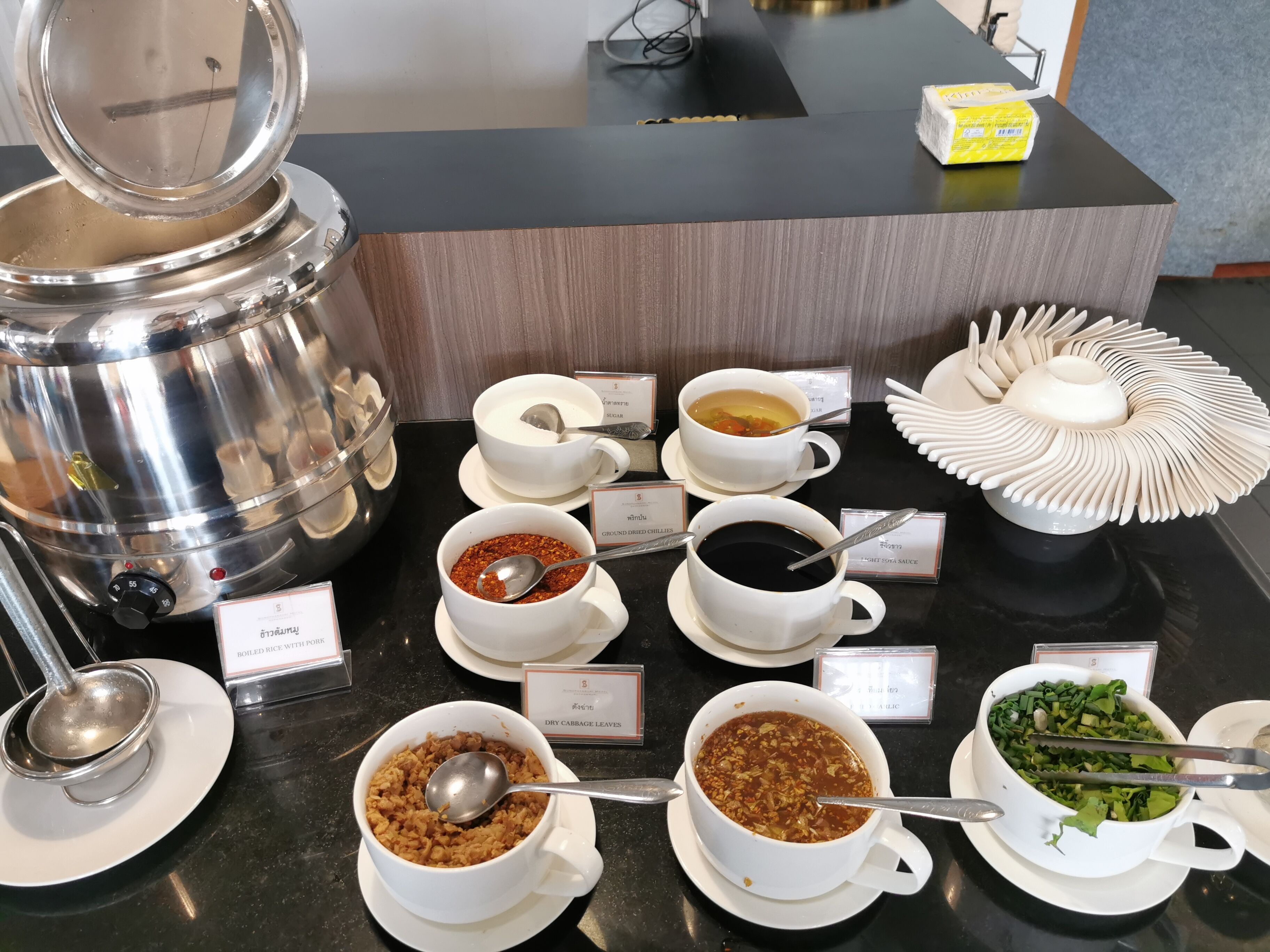 Uma mesa de buffet com diversos alimentos e um canto de café.