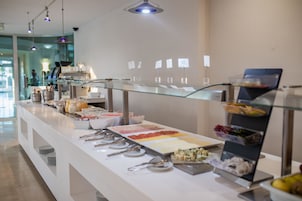 Um buffet com diversos alimentos e utensílios.