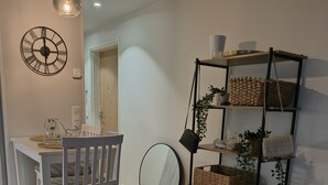 Uma sala de estar moderna com área de refeições, um espelho redondo, estante e um espaço de estar aconchegante.