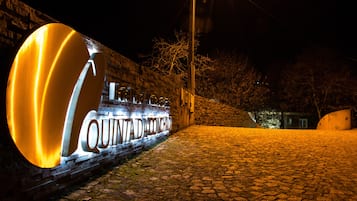 Uma rua de calçada com uma grande placa iluminada para "QUINTADA CONCHA".
