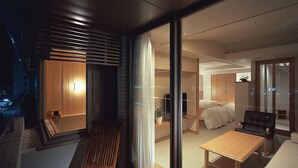 Um interior moderno com uma porta de vidro deslizante que dá para um quarto com cama e sofá.