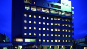 Um hotel com vários andares, um letreiro chamativo no topo, várias sacadas e uma série de janelas em cada pavimento.