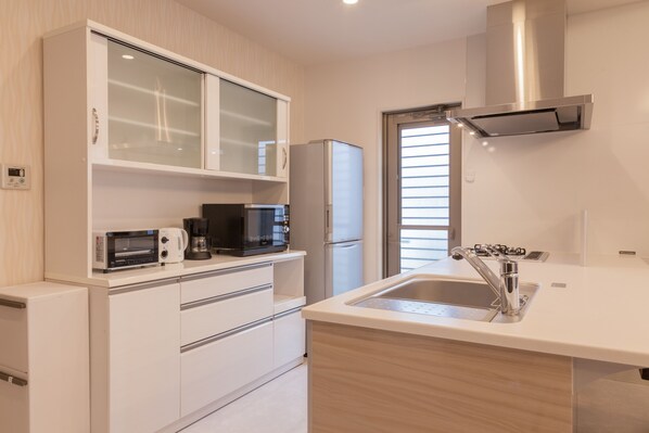 Um frigorífico, um micro-ondas, uma placa de cozinha