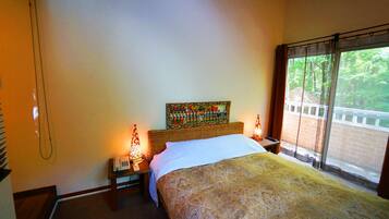 Quarto com uma cama grande, cabeceira decorativa, mesa de cabeceira com abajur e janela com vista para o exterior.