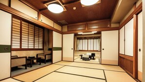 Um quarto japonês tradicional, com piso de tatame, portas deslizantes e teto baixo com iluminação embutida.