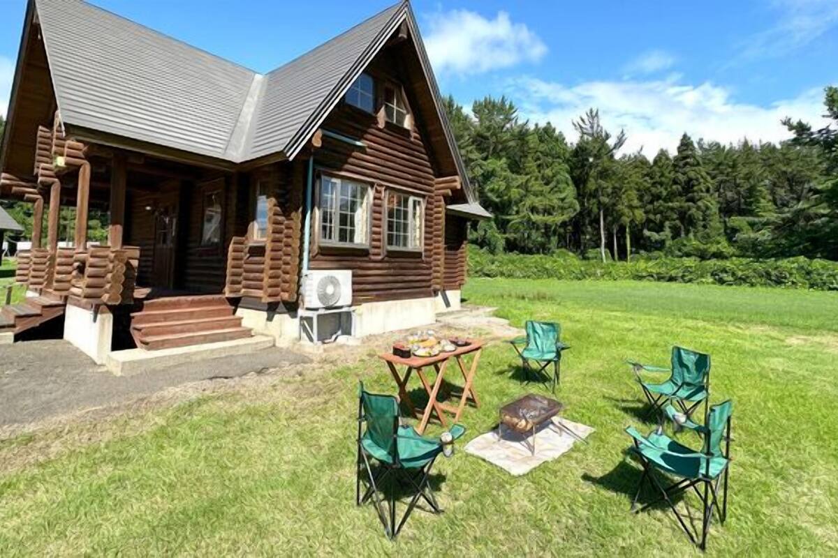 Uma cabana de toras com varanda, área de estar ao ar livre e lareira.