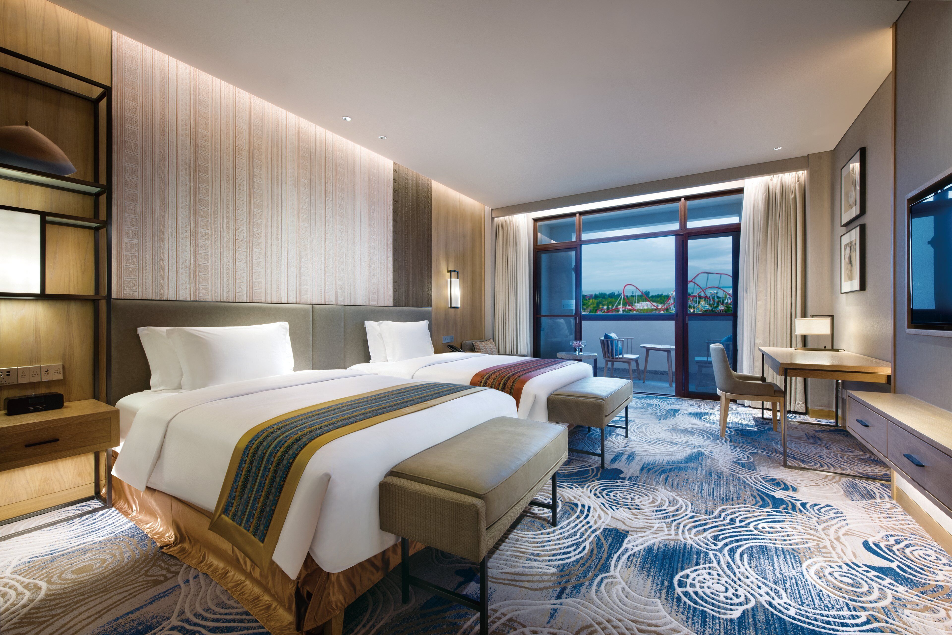 Quarto de hotel com uma cama grande, uma escrivaninha e vista para a cidade.