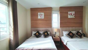 Quarto de hotel com duas camas, cabeceiras de madeira e obras de arte nas paredes.
