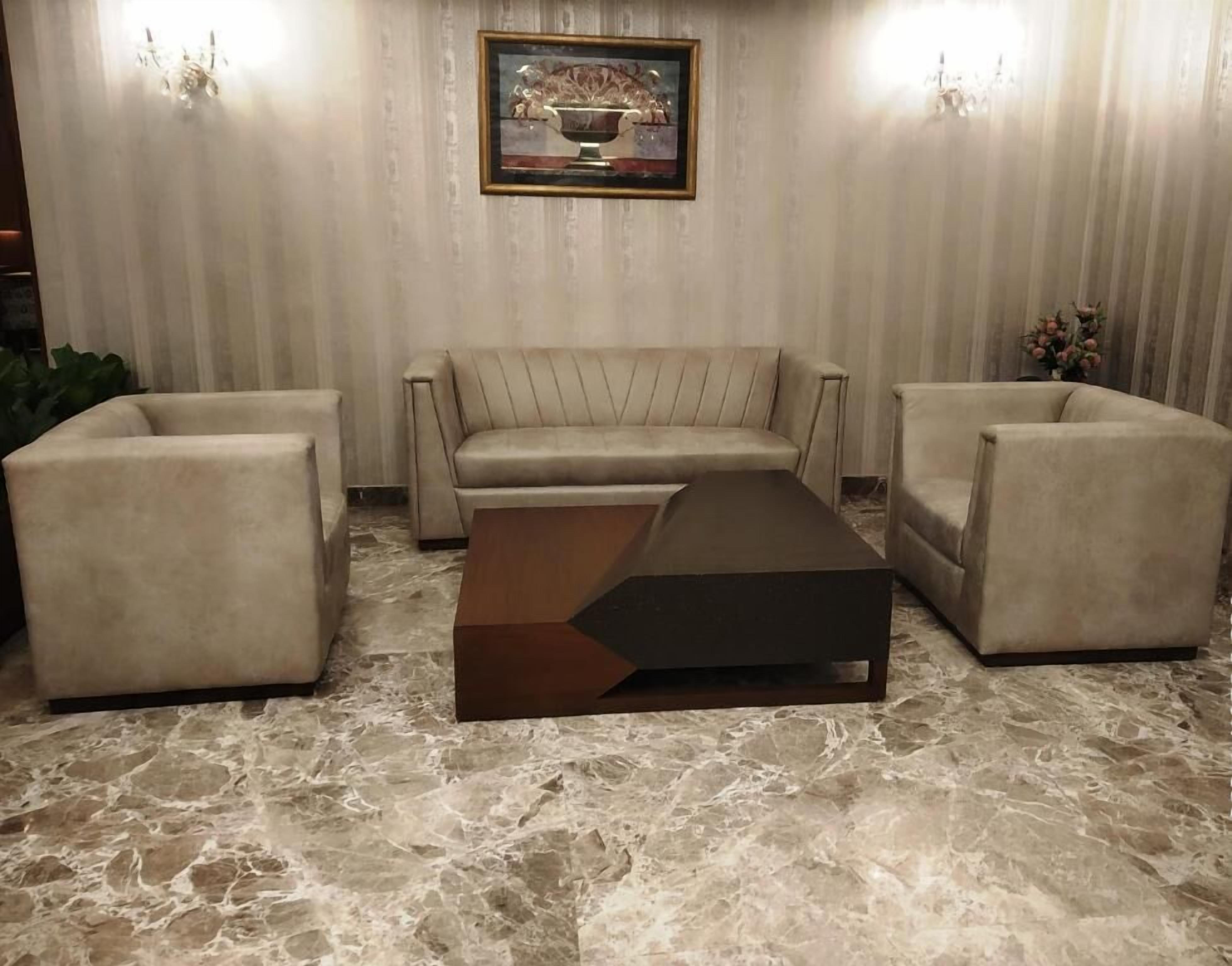 Sala de estar com sofá, mesa de centro e um quadro na parede.
