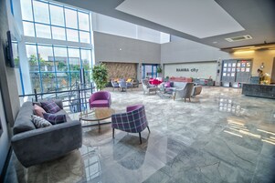 Um hall amplo com design moderno, com diversos tipos de assentos e uma área de recepção visível.