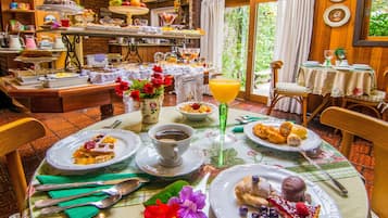 Uma mesa posta para dois, com pratos de comida, uma xícara de café e uma tigela de frutas.