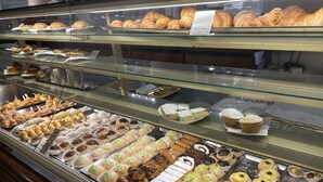 Vitrine de pastelaria com diversos doces e sobremesas.