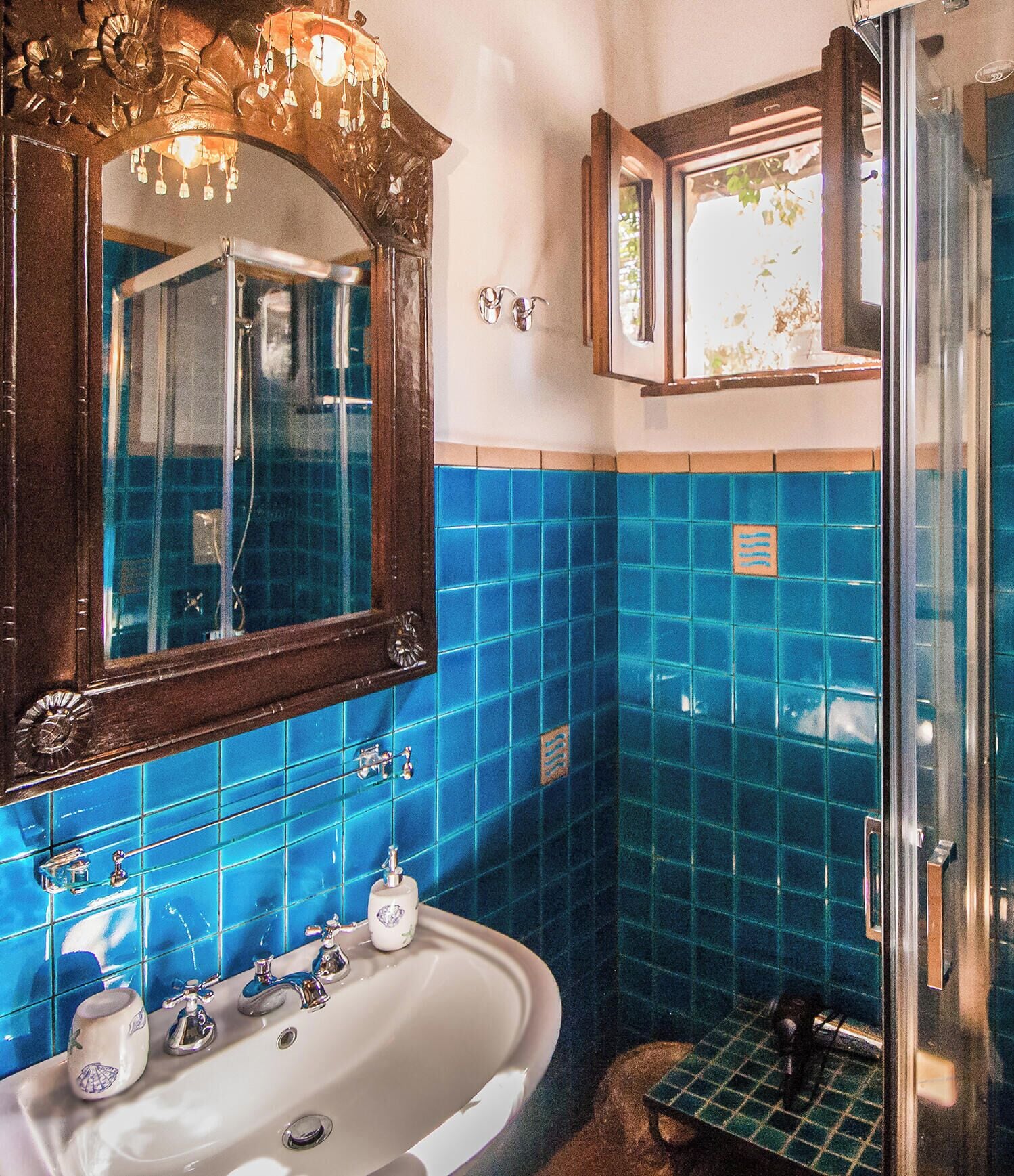Casa de banho com um espelho grande, uma banheira, lavatório com duas torneiras e zona de duche.
