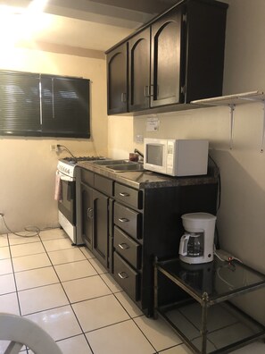 Um frigorífico/congelador grande, um micro-ondas, utensílios de cozinha 