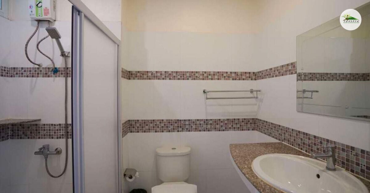 Uma casa de banho com chuveiro, sanita e lavatório.