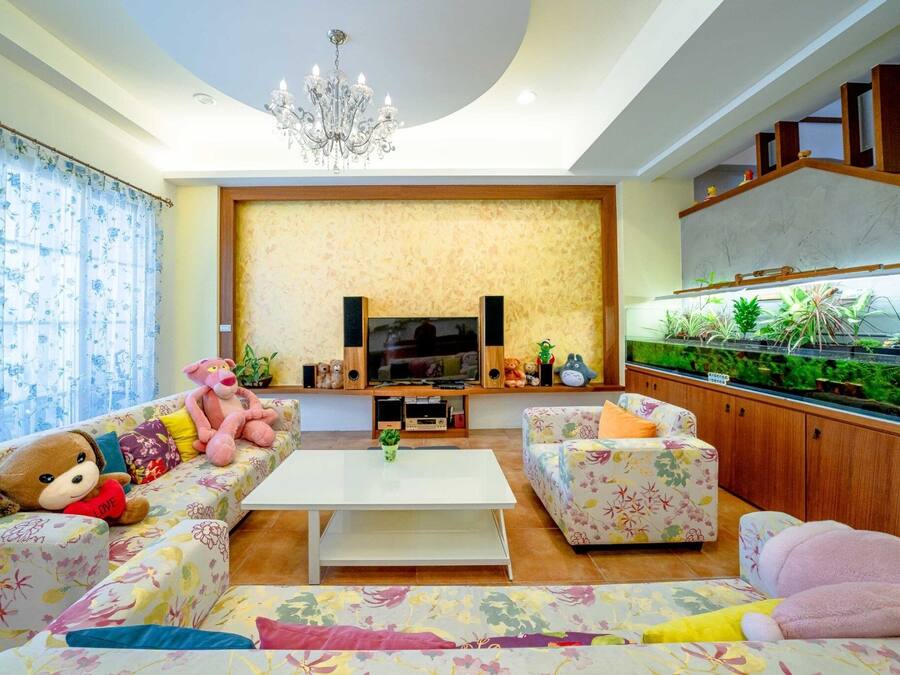 Uma sala de estar com sofá, mesa de centro, televisão e aquário.