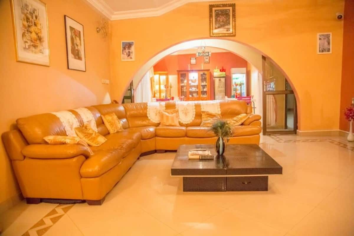 Sala de estar com um amplo sofá em formato de L, uma mesa de centro e vista através de um arco para uma área de jantar.