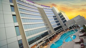 Hotel com design moderno, piscina e áreas de estar ao ar livre.