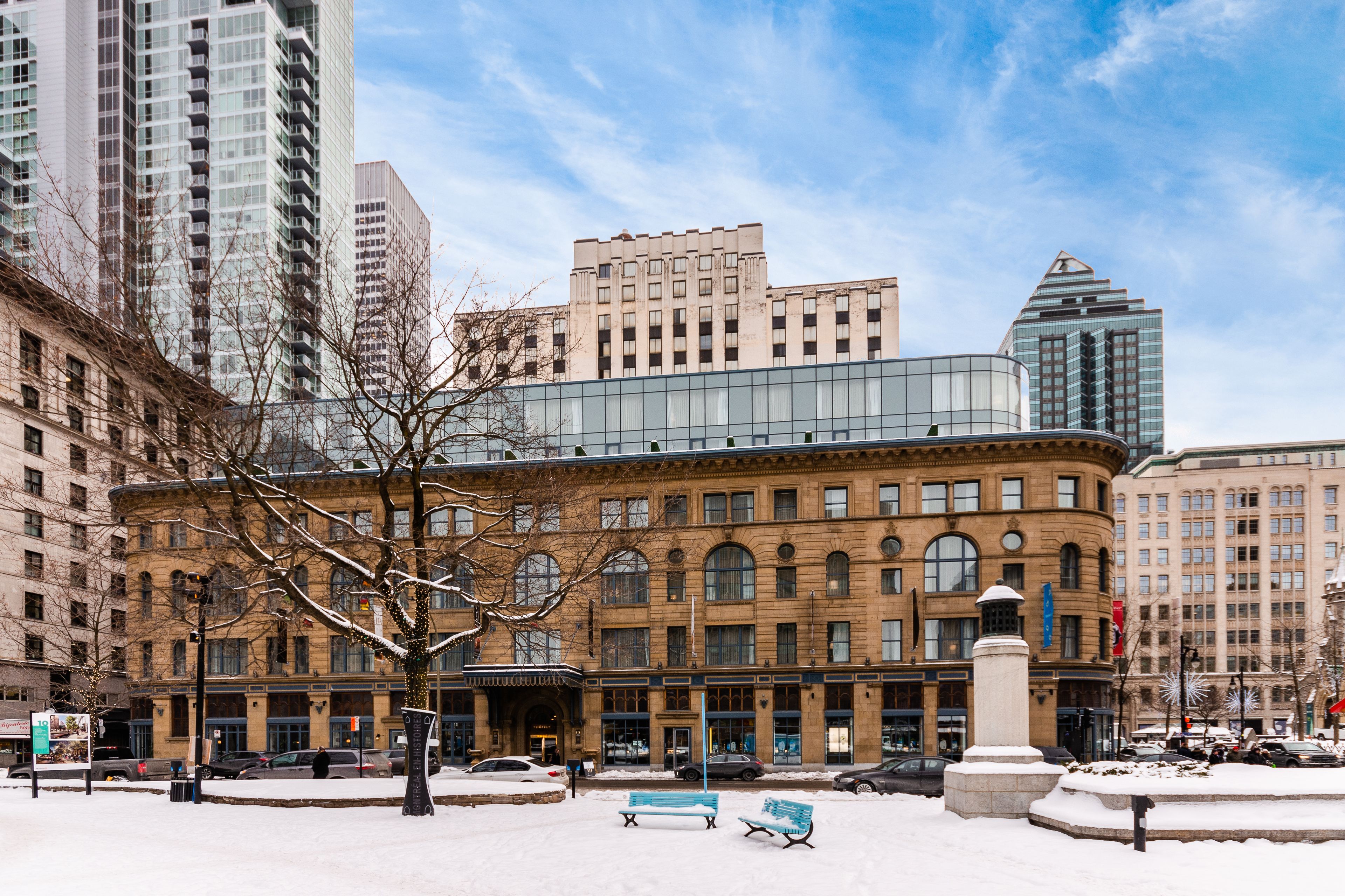 Um edifício histórico com pátio central, bancos e chão coberto de neve.