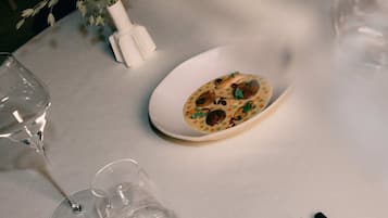 Uma mesa de jantar com um prato de comida, um copo de água e talheres.