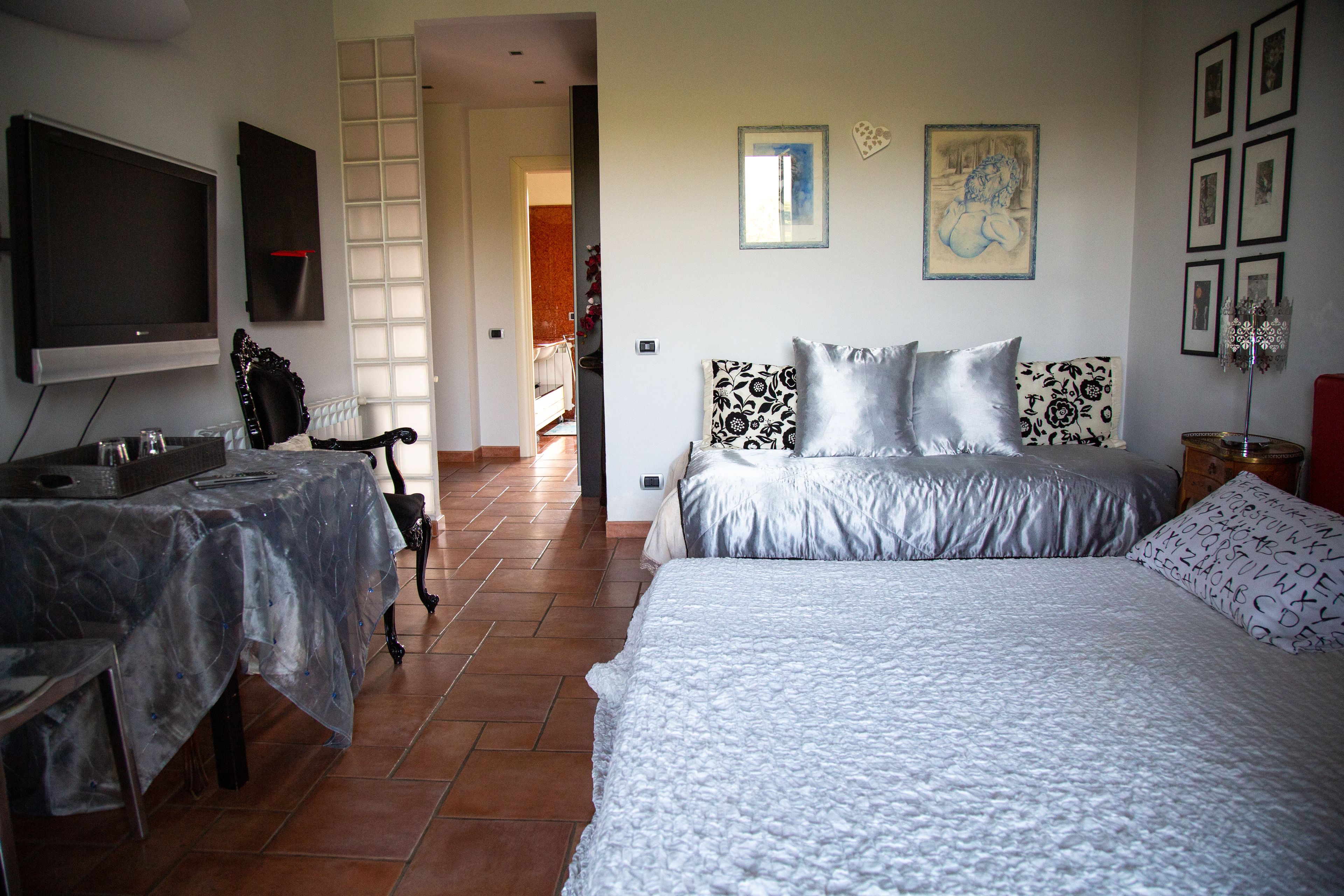 Quarto com uma cama grande, televisão e mesa de jantar.