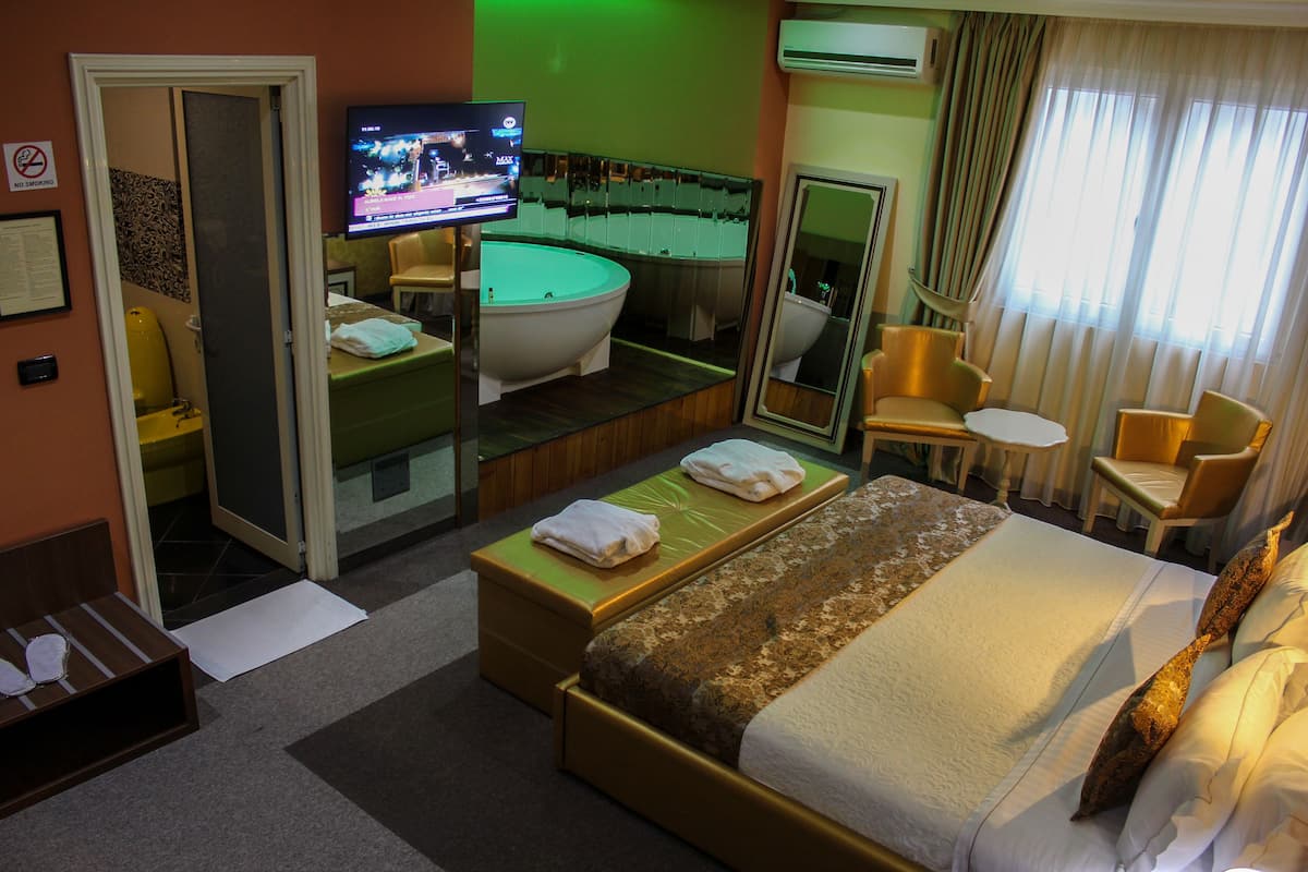 Suíte, 1 cama Queen | Sala de estar | TV de tela plana