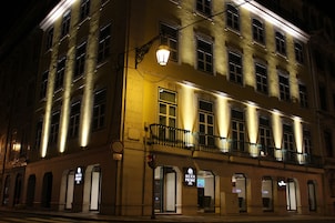 Um edifício de vários andares com janelas iluminadas e uma placa com a inscrição 'MERA PRIME'.