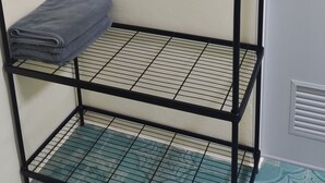 Uma cama beliche com estrutura metálica e uma prateleira.