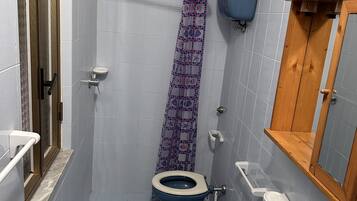 Uma casa de banho pequena com sanita, bidé e lavatório.
