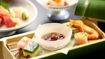 Uma refeição tradicional japonesa com diversos pratos, incluindo sashimi, legumes e uma tigela de sopa.
