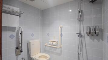 Uma casa de banho moderna com sanita, chuveiro e secador de mãos.