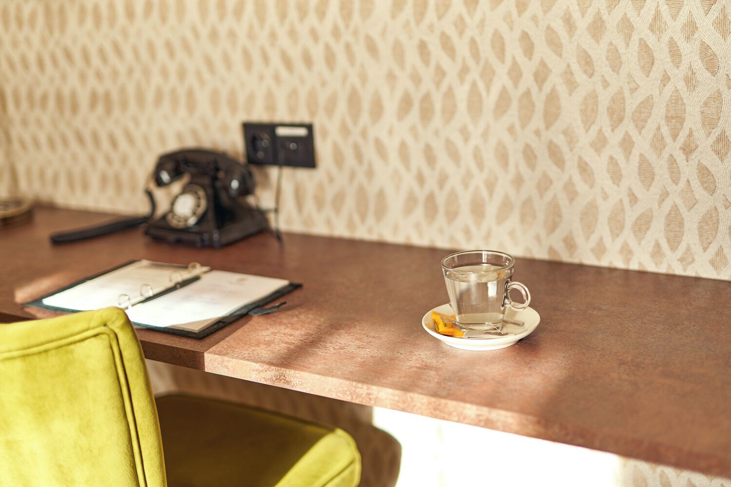 Uma mesa com uma xícara de chá, um rádio antigo e um caderno.