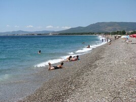 Uma praia privada, espreguiçadeiras, guarda-sóis de praia 