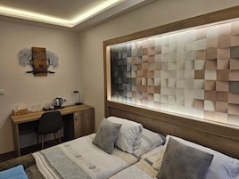Quarto com uma cama, uma escrivaninha e uma obra de arte na parede.