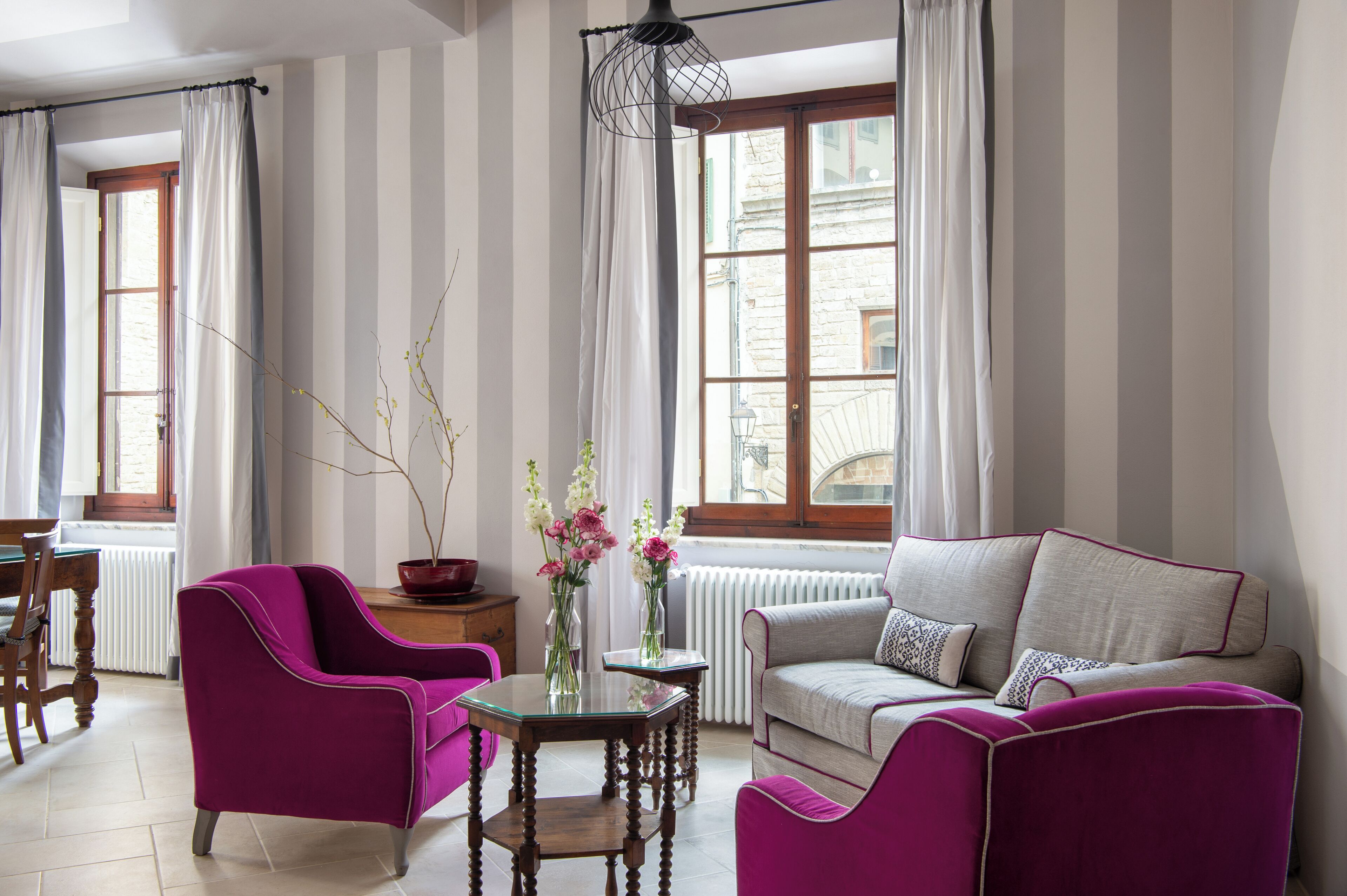 Quarto com sofá, poltronas, uma mesa e um vaso de planta.