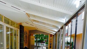 Um saguão de hotel com piso estampado, um balcão de recepção e áreas de estar.
