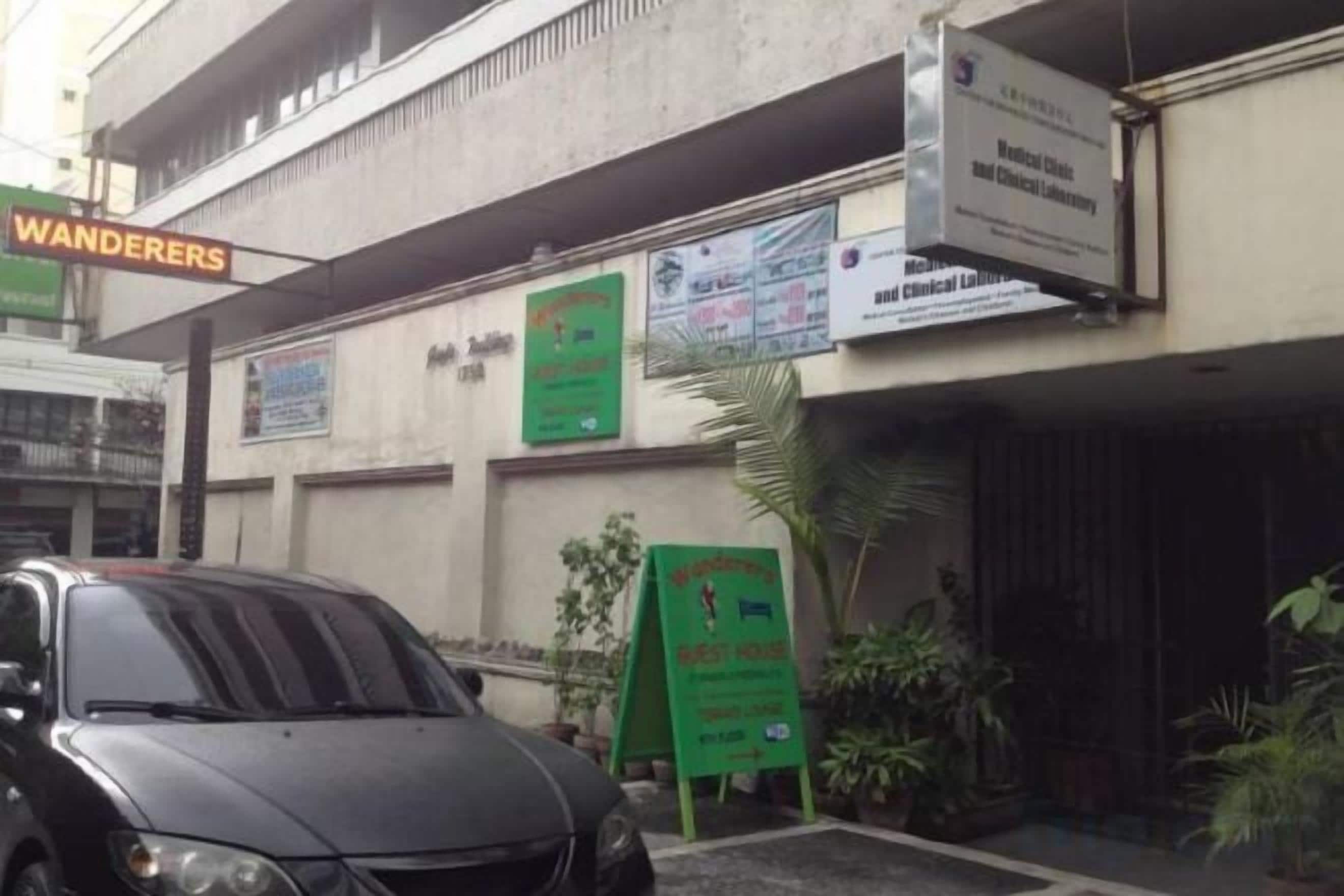Um edifício com várias placas, incluindo uma para Wanderers e outra para um laboratório médico.