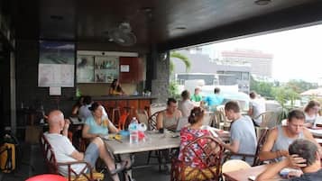 Restaurante com área externa, bar e vista para a cidade.