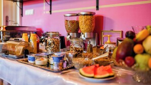 Um buffet de café da manhã com diversos alimentos e recipientes.