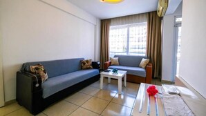 Uma sala de estar moderna com um sofá, uma mesa de centro e uma janela com cortinas.