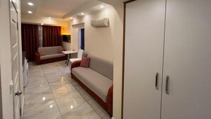 Quarto de hotel moderno com sofá, uma mesinha e um guarda-roupa.