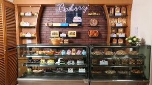 Vitrine de padaria com diversos pães e doces.